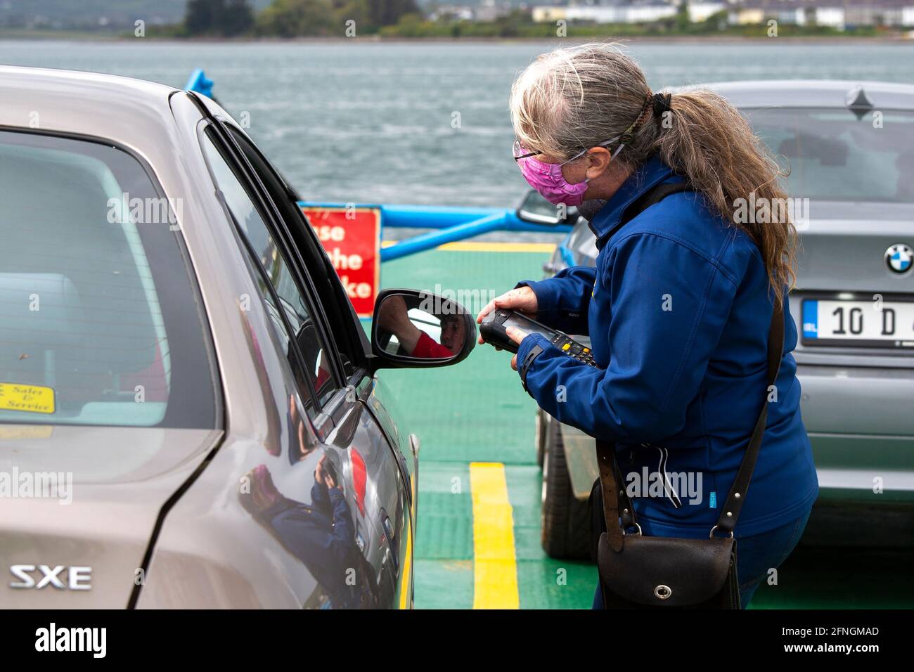 Deck supervisor collecting fares using mobile phone app, on the ...