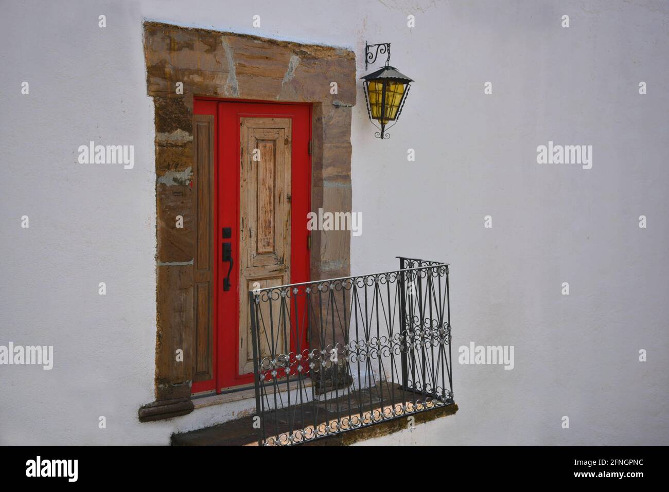 Colonial house red wooden door with stone trim and a handcrafted iron ...