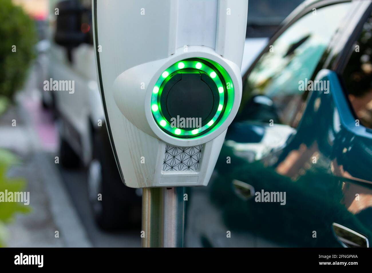 A battery charging point for electric cars, illuminated with green LEDs ...