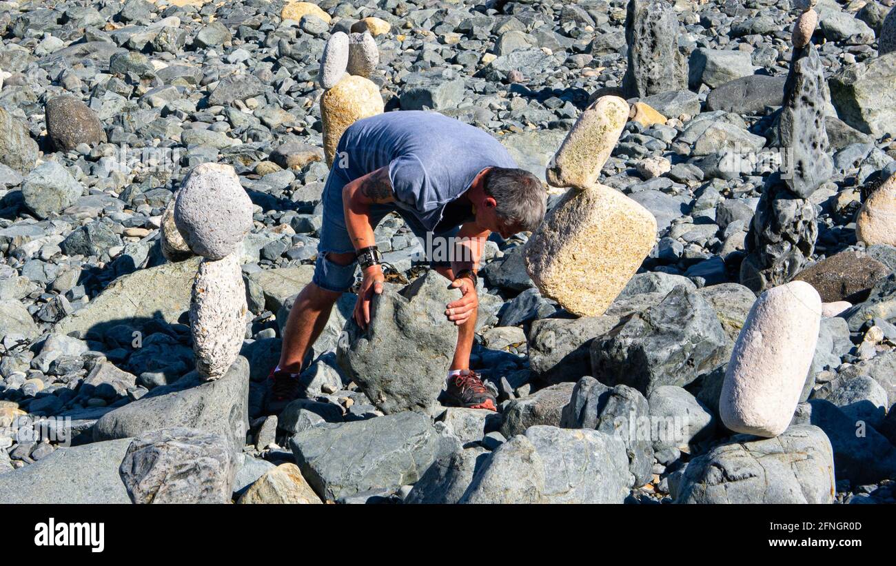 Pebble sculptures on St Ives beach Cornwall. Pebble sculptor at work ...