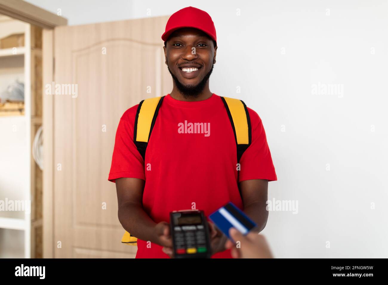 Portrait of black man holding POS machine for payment Stock Photo - Alamy