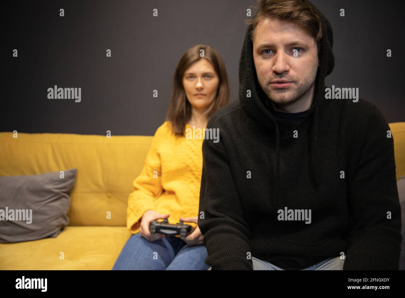 Unconcerned, calm, concentrated unemotional couple playing video games ...