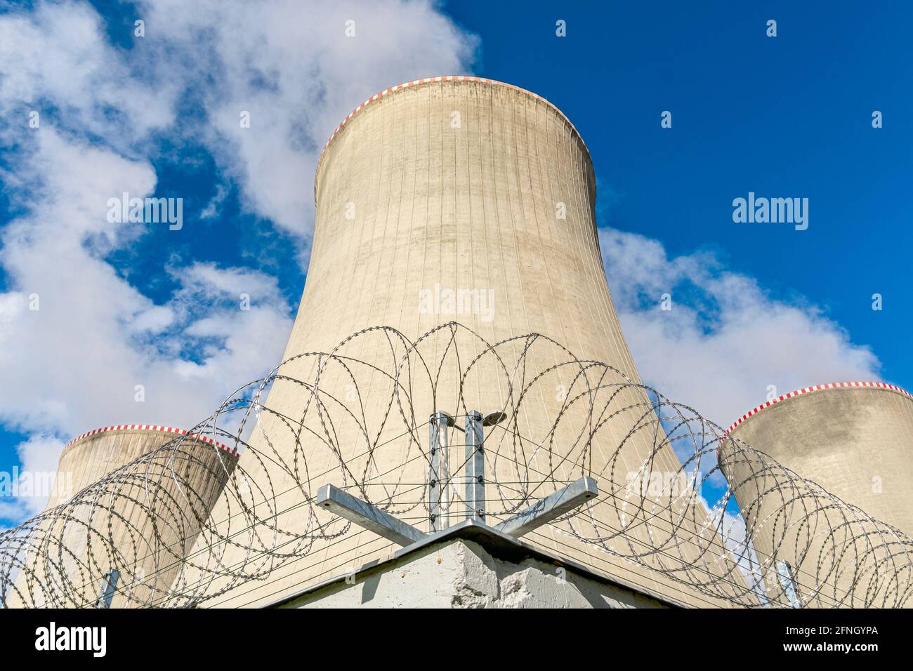 Cooling tower of a nuclear power plant behind barbed wire. Object under ...