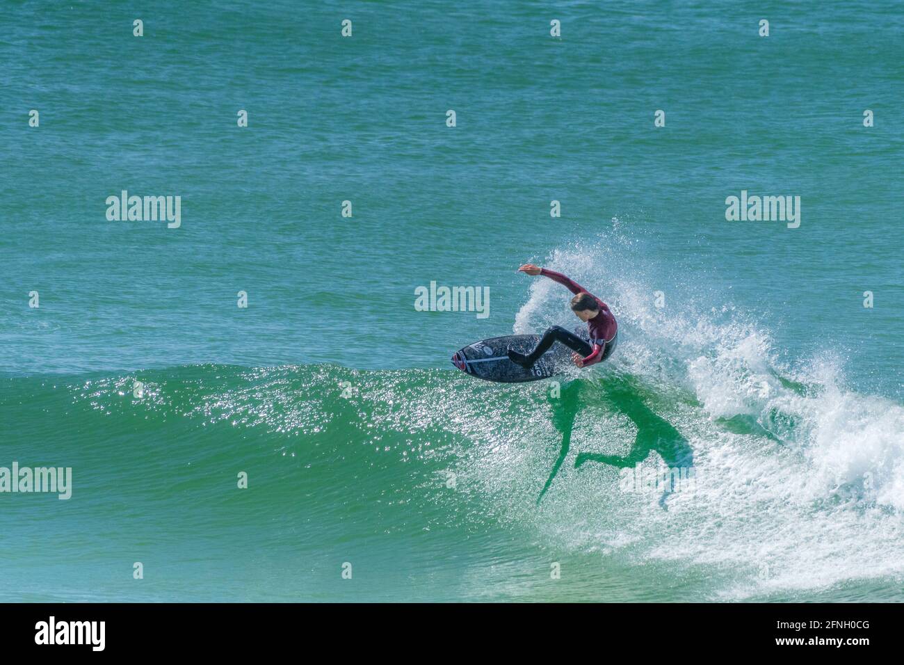 Surfing action as a surfer makes a spectacular turn off the crest of a ...