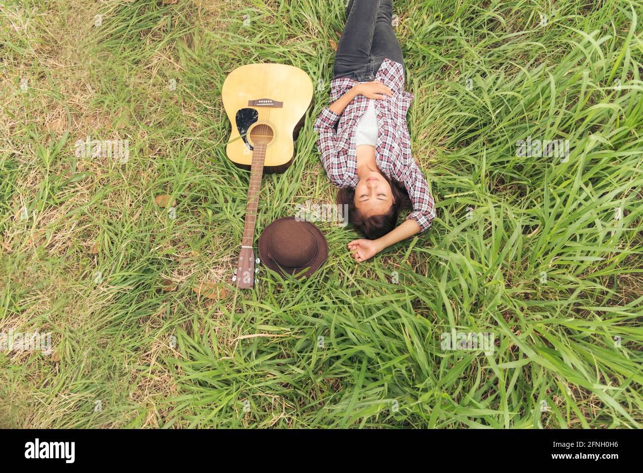 Top view of woman lay down on meadow with guitar instrument Stock Photo ...
