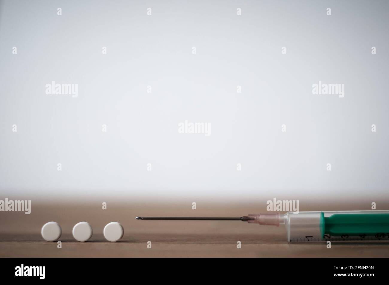Tablets and syringe with free space Stock Photo - Alamy