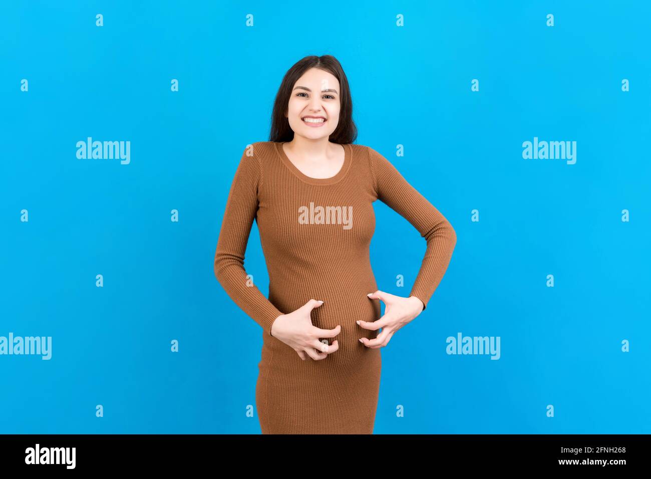 Pregnant woman scratching her belly on colored background Stock Photo ...