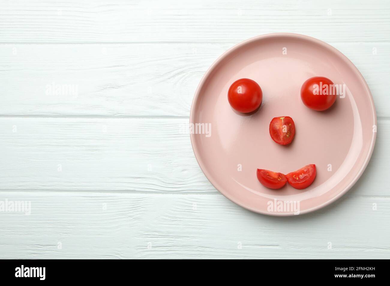 Plate with happy face made of tomato on white wooden background Stock ...