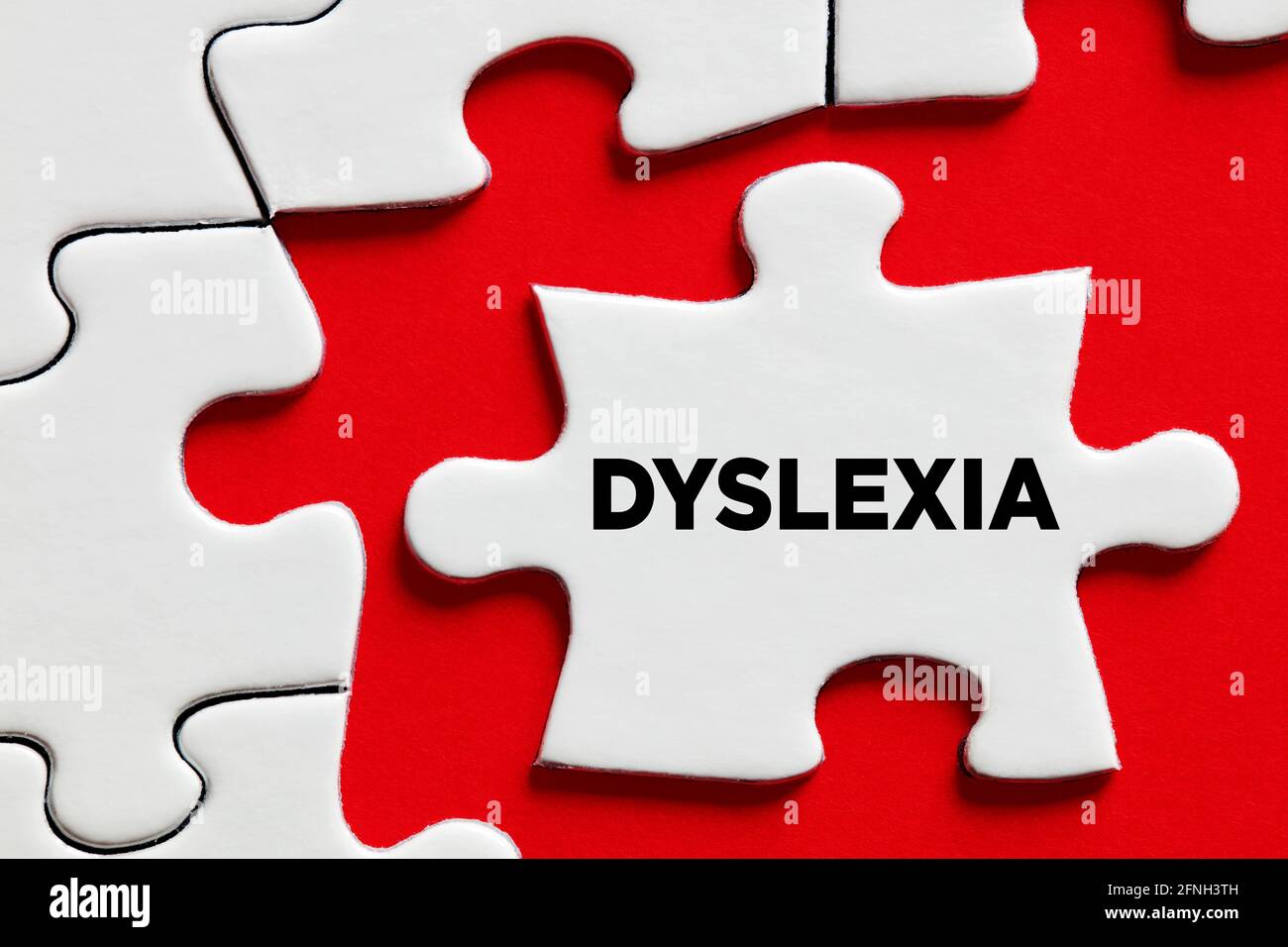 The word dyslexia on a puzzle piece with red background Stock Photo - Alamy