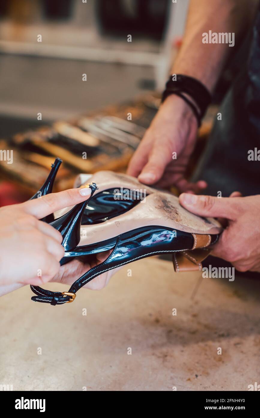 Customer bringing shoes to the shoemaker for a repair Stock Photo - Alamy