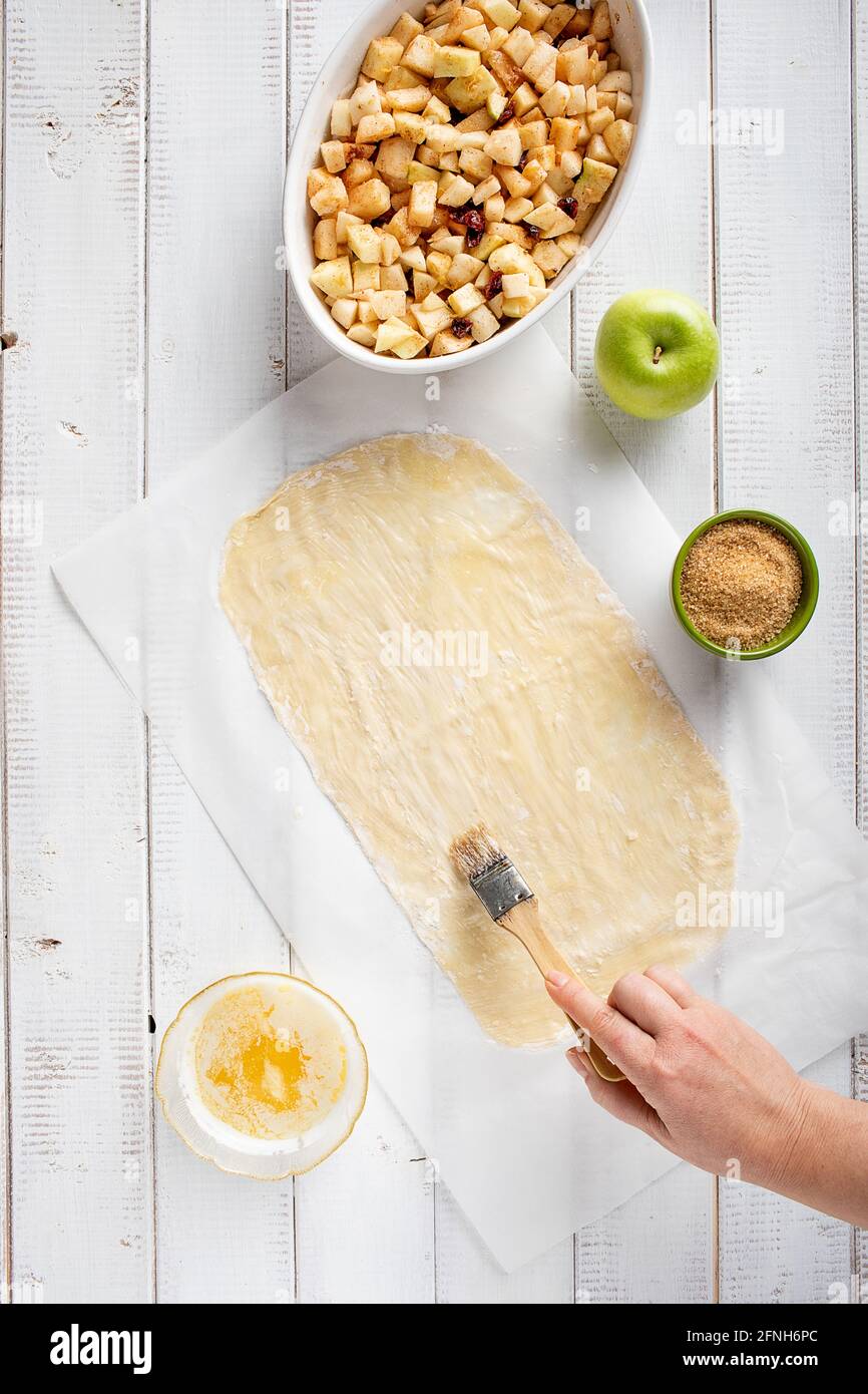 Brush phyllo dough with melted butter - Apple strudel preparation Stock ...