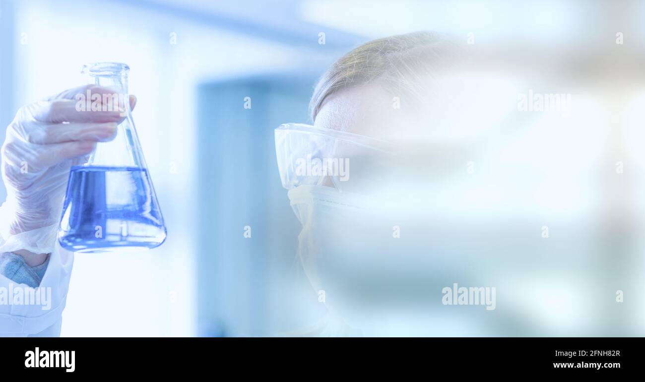 Composition of female scientist holding flask with fluid in lab with ...