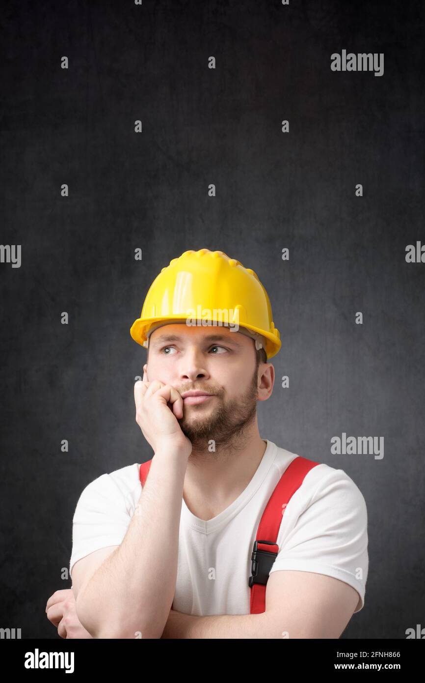 Disappointed construction worker with yellow hard hat Stock Photo - Alamy