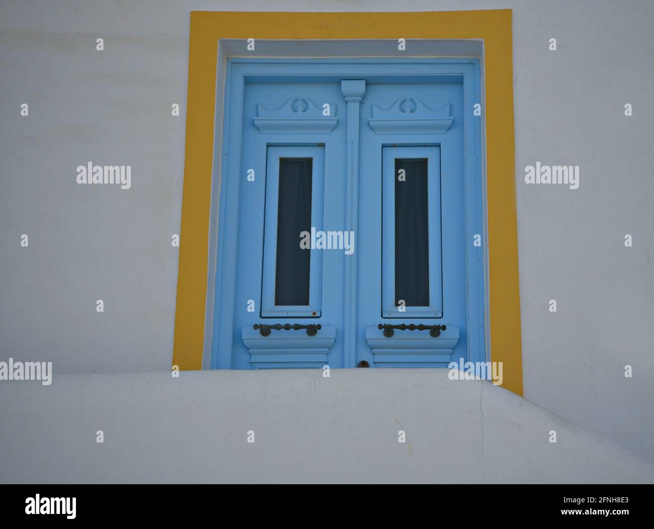 Neoclassical house facade with a whitewashed wall and a light blue ...