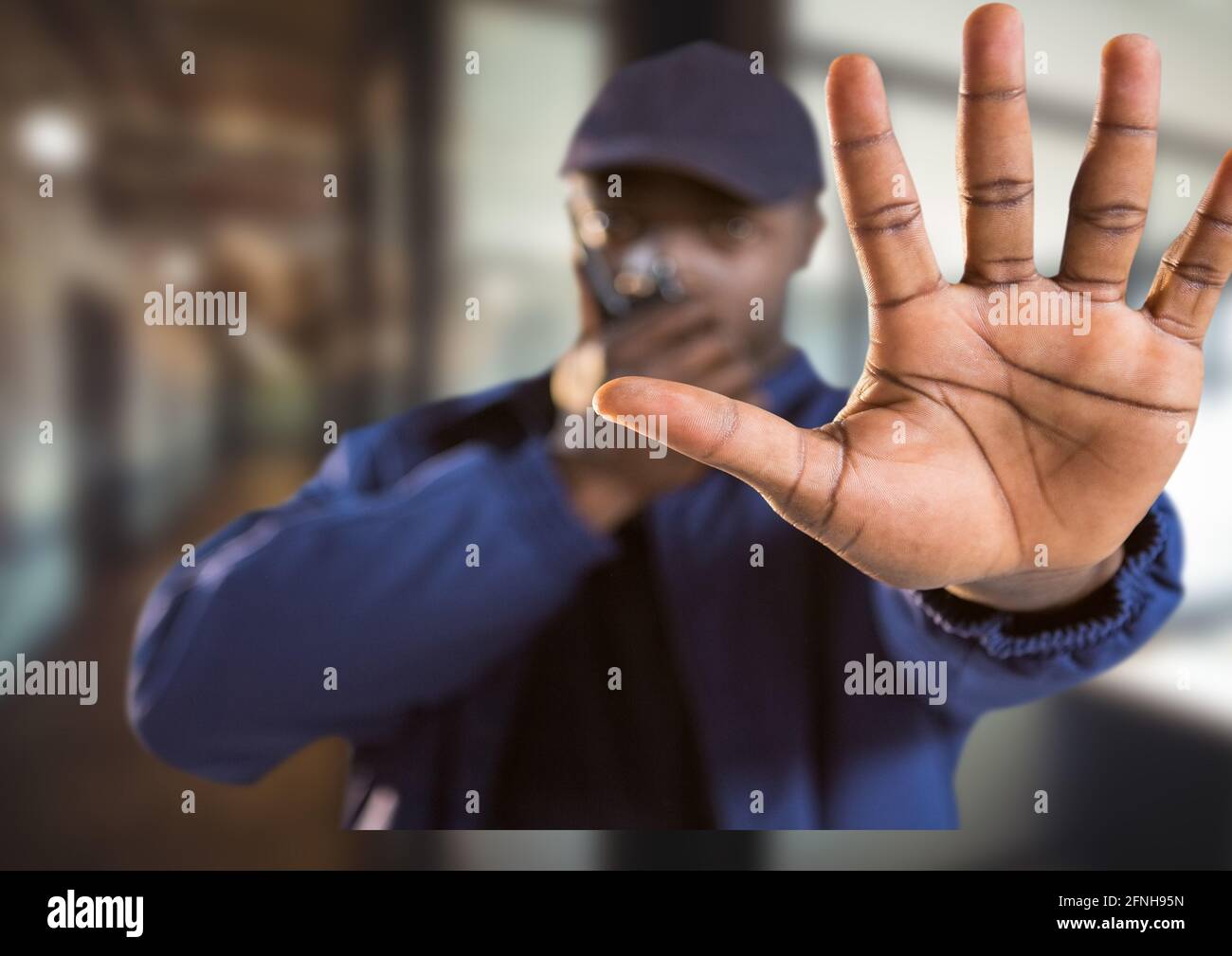 Composition of male security guard using walkie talkie holding hand out ...