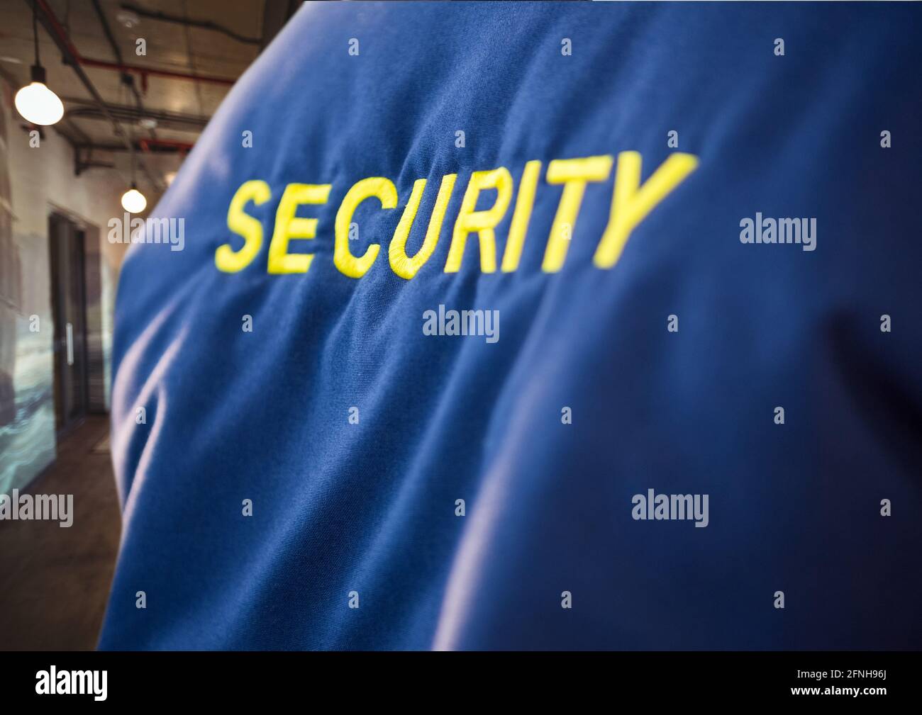 Composition of midsection of security guard blue jacket with yellow ...