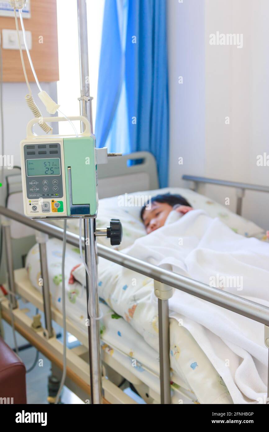 Illness asian boy lying on sickbed in hospital with infusion pump ...