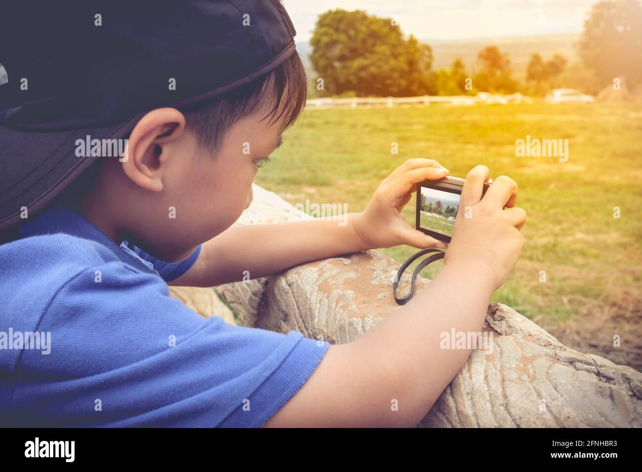 Side view of asian boy with camera at park . Children were photographed ...