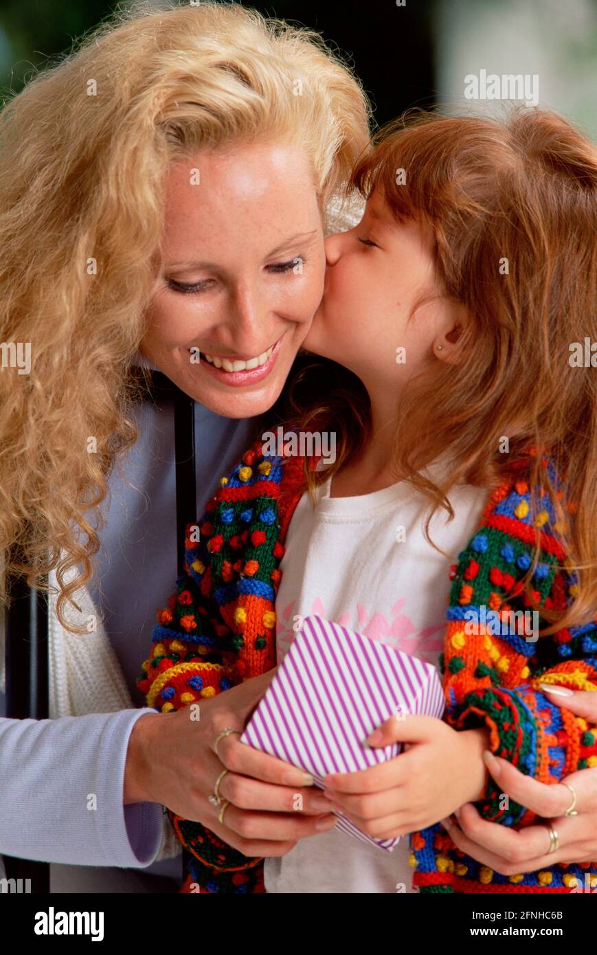 Mother giving daughter kiss on hi-res stock photography and images - Alamy