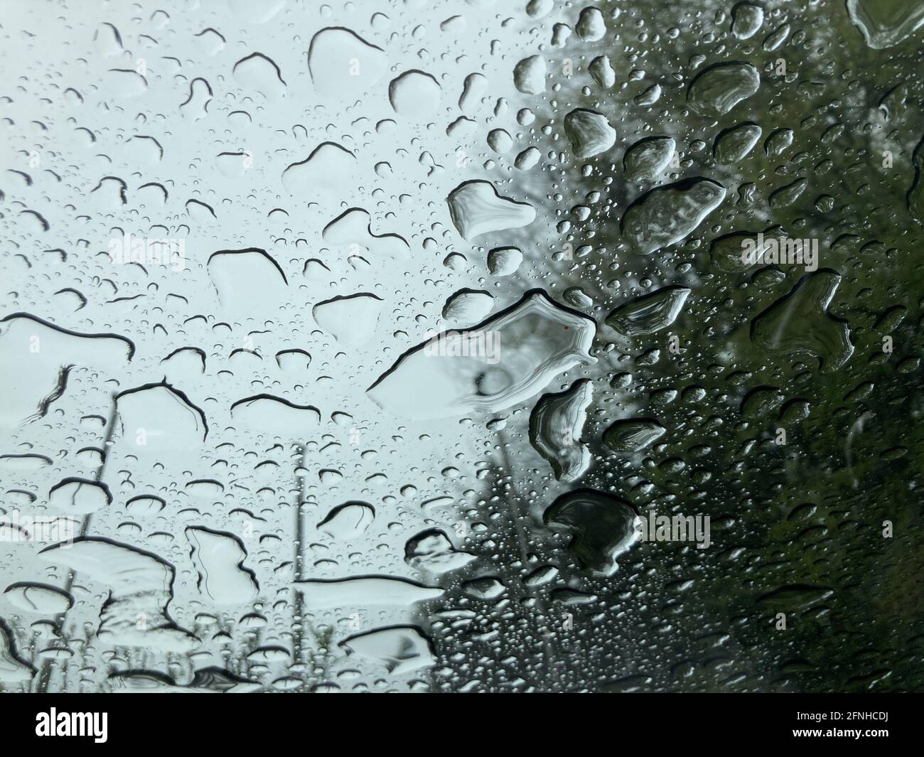 Closeup shot of large raindrops on a front window of a car Stock Photo ...