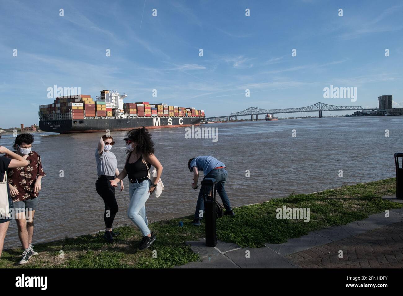 People watch as a massive MSC container ship carrying global cargo ...