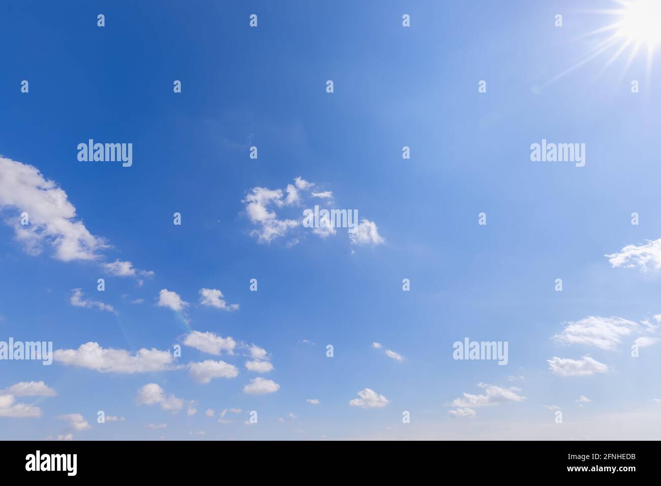 Blue sky with clouds with perspective and sun with rays in the upper ...