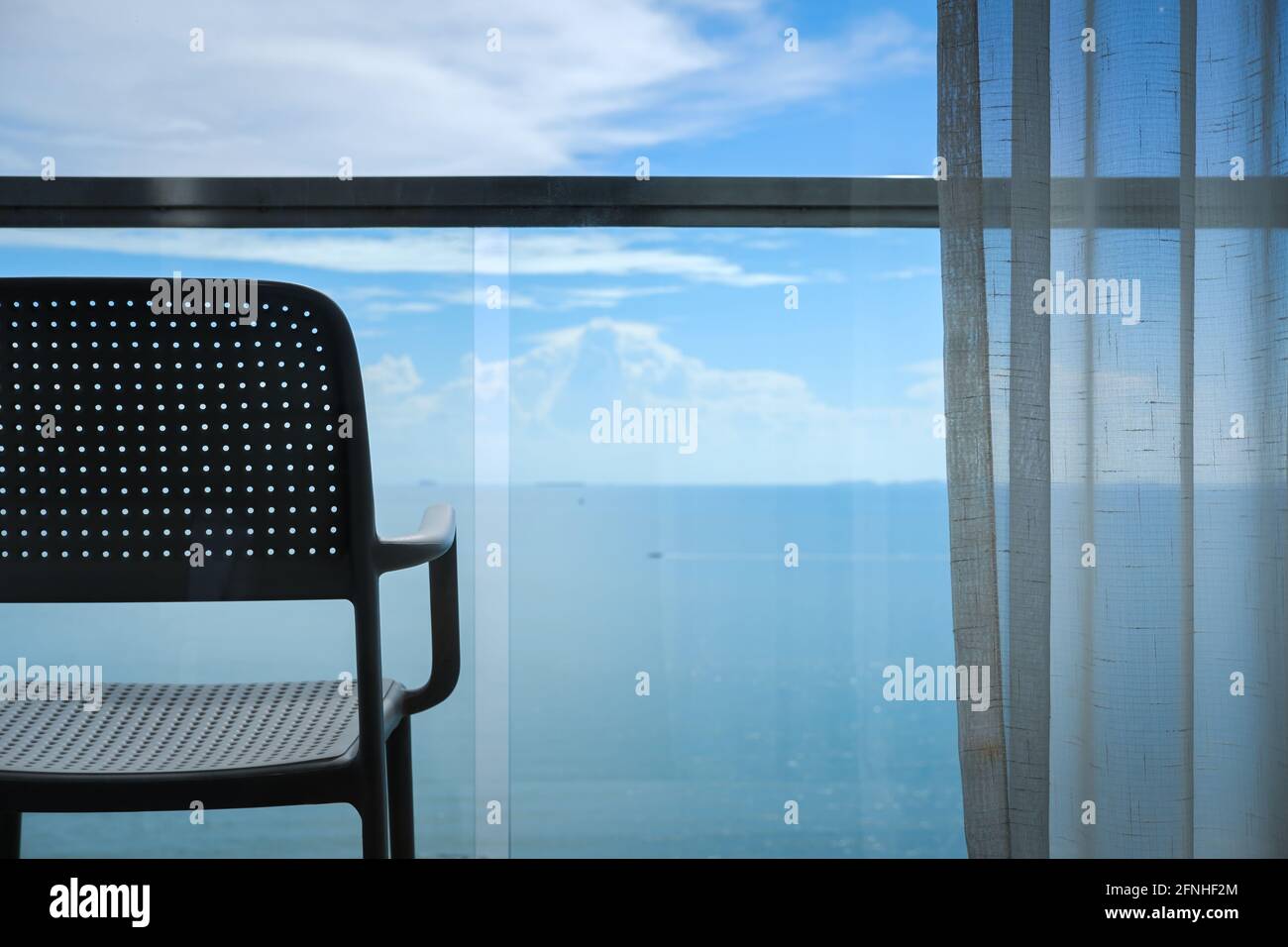 Back view from the window of chair on the balcony, sea and sky ...
