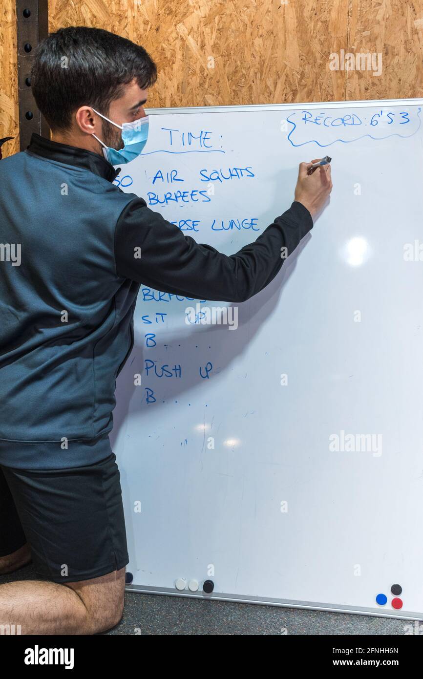 Personal trainer writing exercise chart on a whiteboard Stock Photo - Alamy