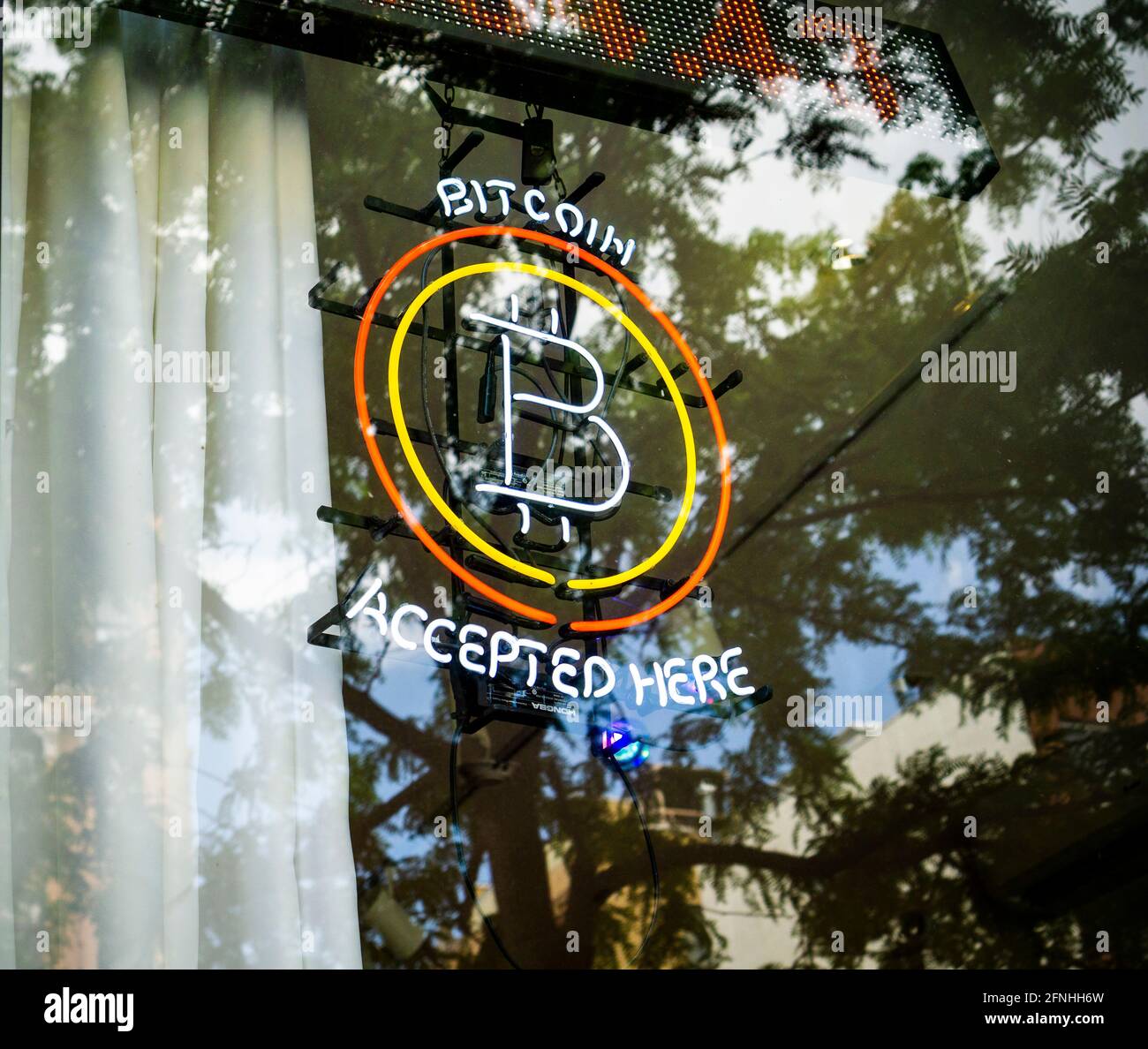 Bitcoin accepted here is displayed in the window of a store in the East ...