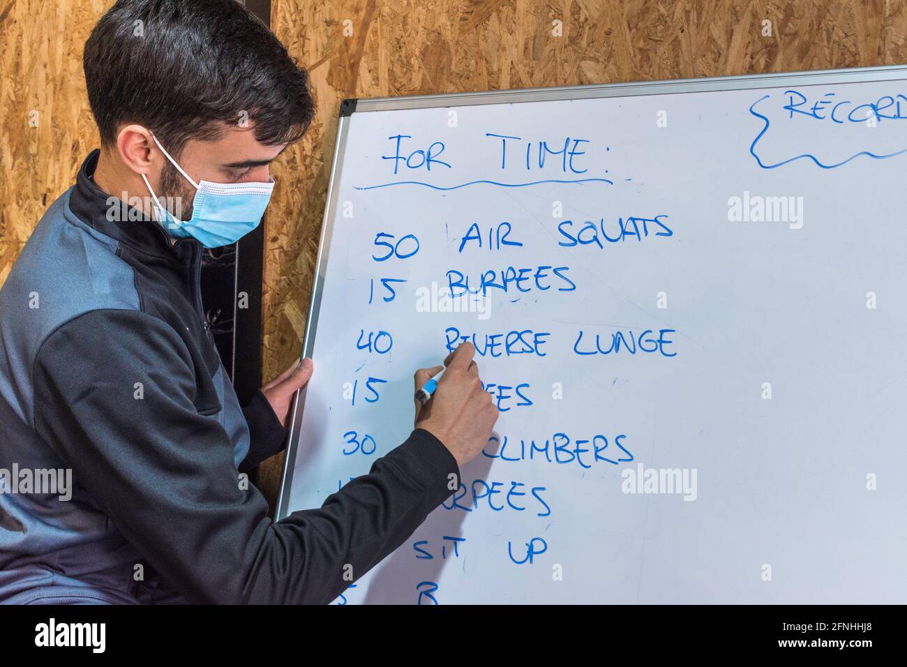 Personal trainer writing exercise chart on a whiteboard Stock Photo - Alamy