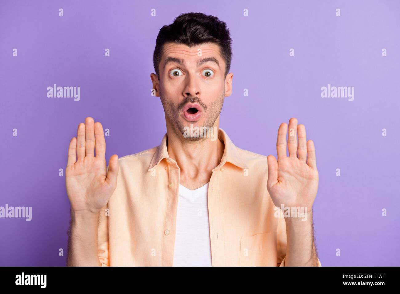 Portrait Of Impressed Brunet Guy Hands Up Stop Wear Peach Shirt