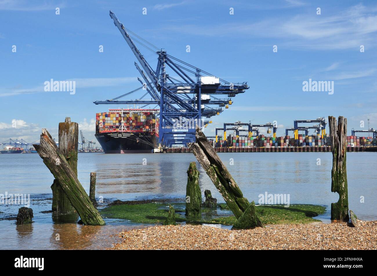 Old timber posts frame the Container ship MSC Leanne dockside at the ...