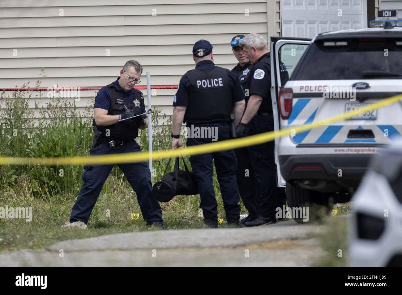 Chicago police officers work at the scene where two officers were shot ...