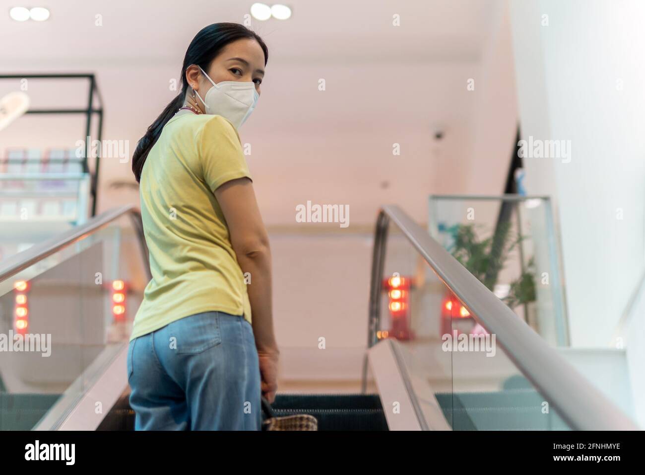Woman with protective mask looking back at camera Stock Photo - Alamy