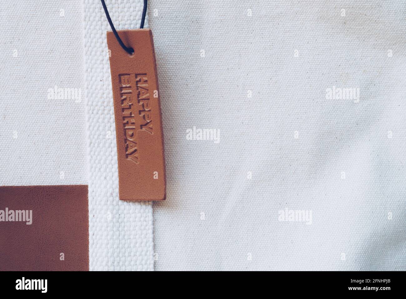 Close up Leather tag on bag with text Happy birthday Stock Photo - Alamy