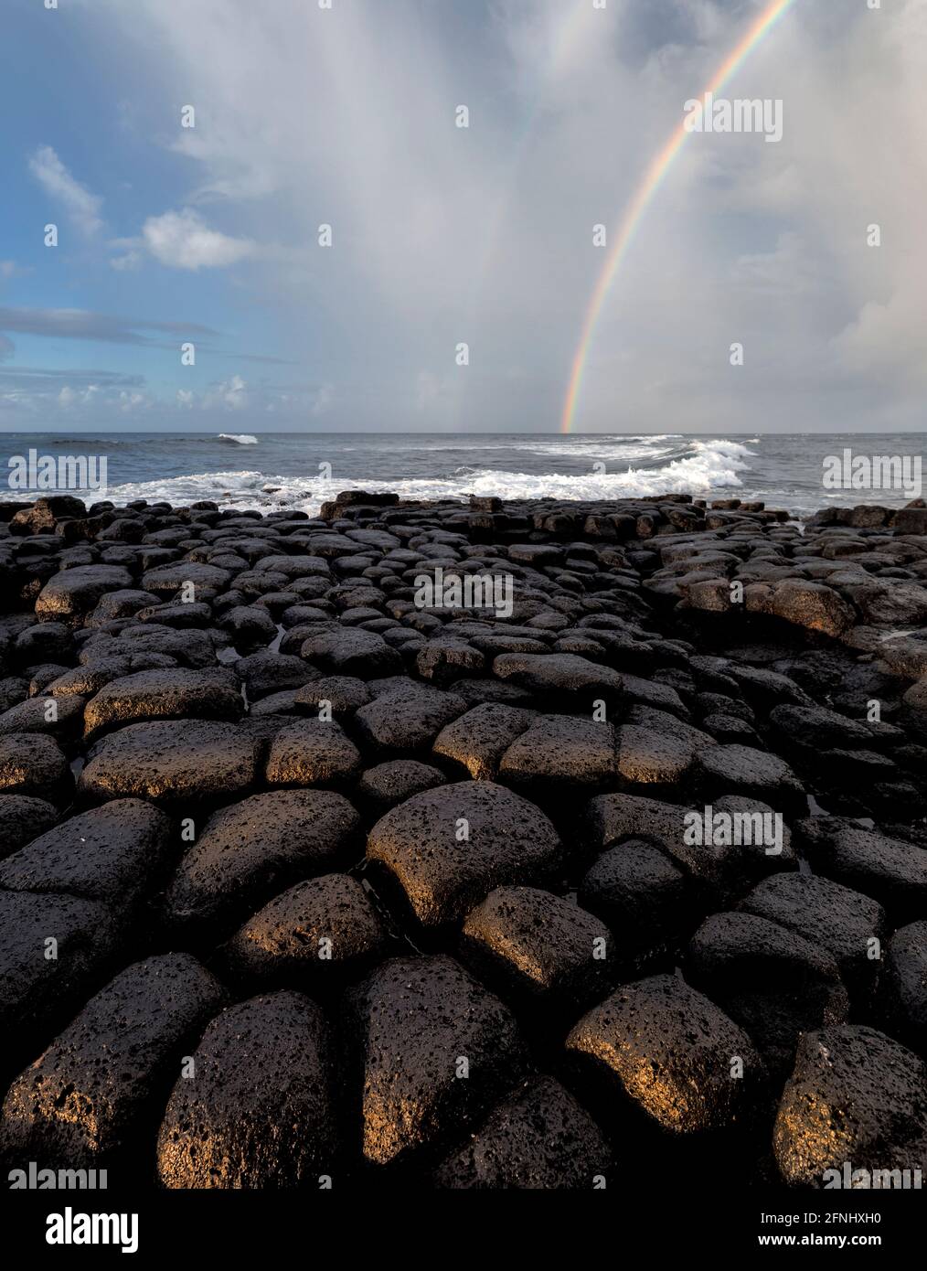 Basalt columns and rainbow with storm clouds. Kauai, Hawaii Stock Photo ...