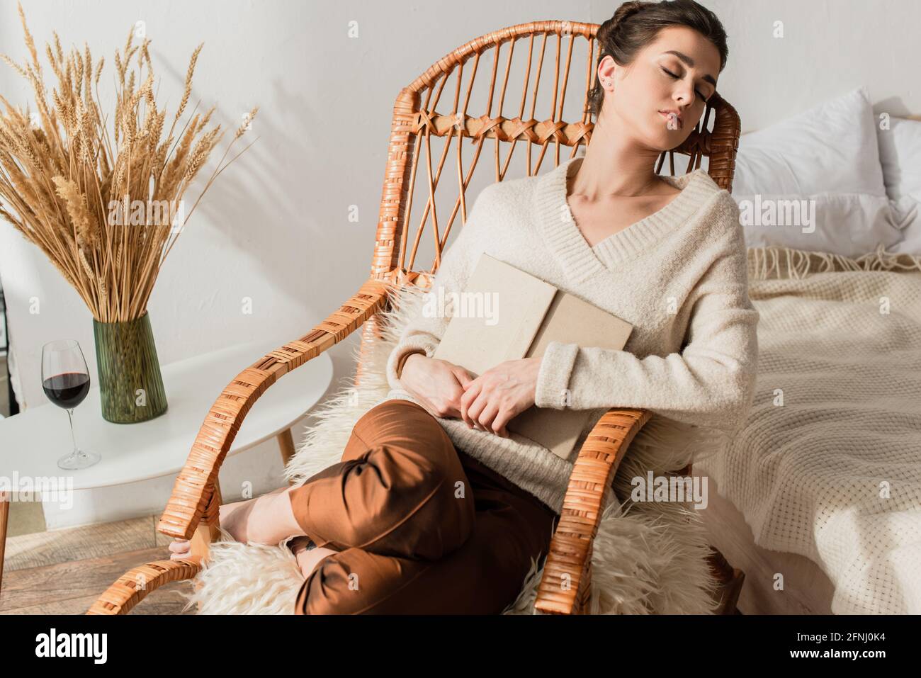 young woman sleeping in rocking chair with book Stock Photo - Alamy