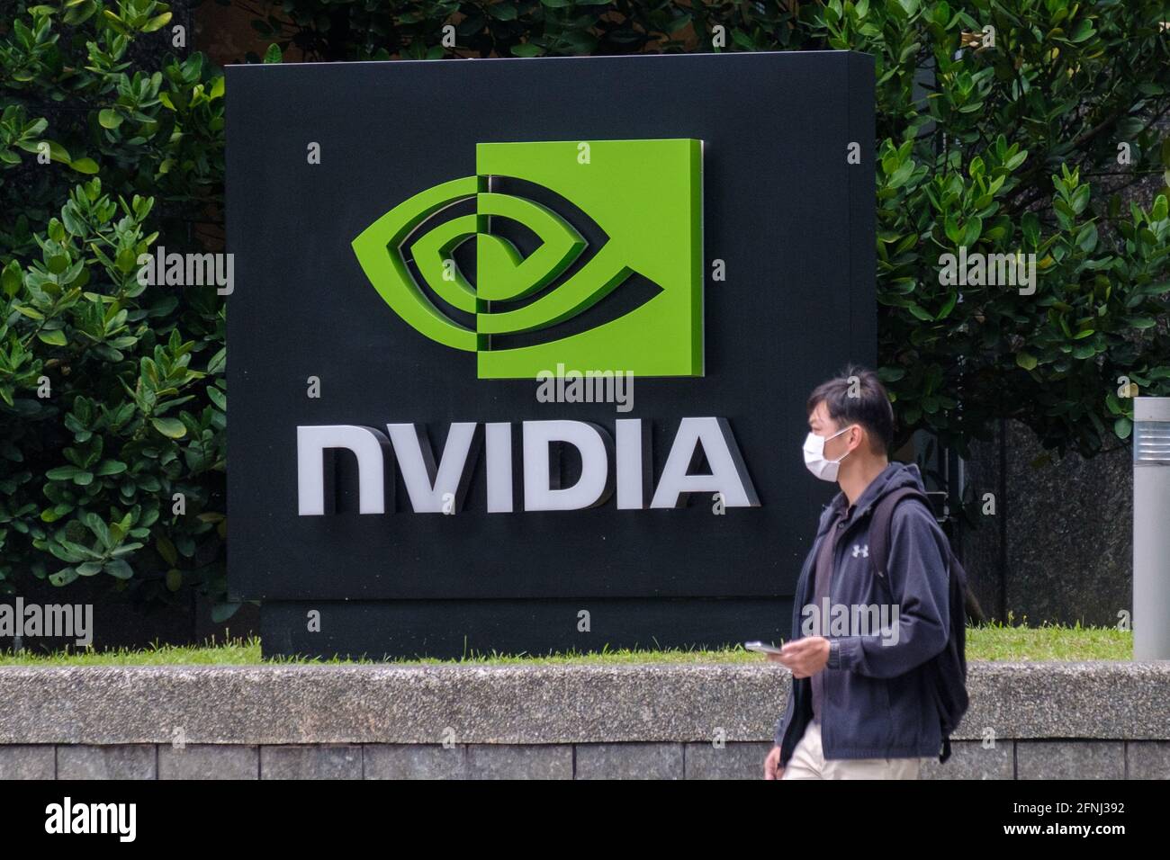 A man wearing a mask walks past an Nvidia logo in Taipei. (Photo by ...