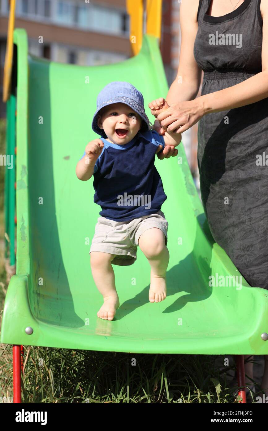 Excited child is jumping on a slide Stock Photo - Alamy