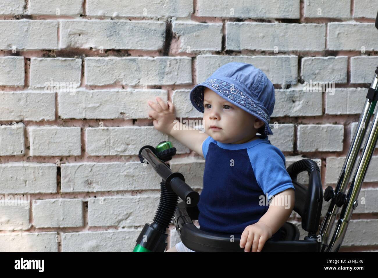 Portrait of serious child on a brick wall background Stock Photo - Alamy