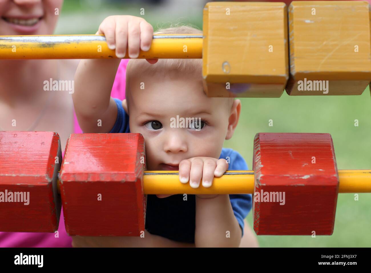Little child is hiding behind wooden blocks at playground Stock Photo ...