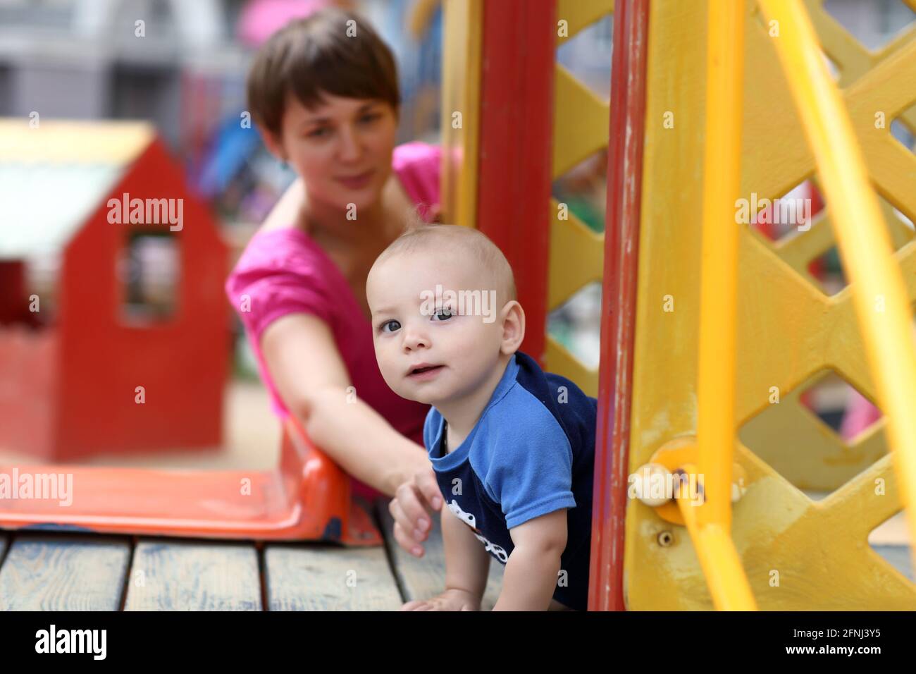 Portrait of curious baby on a slide at playground Stock Photo - Alamy