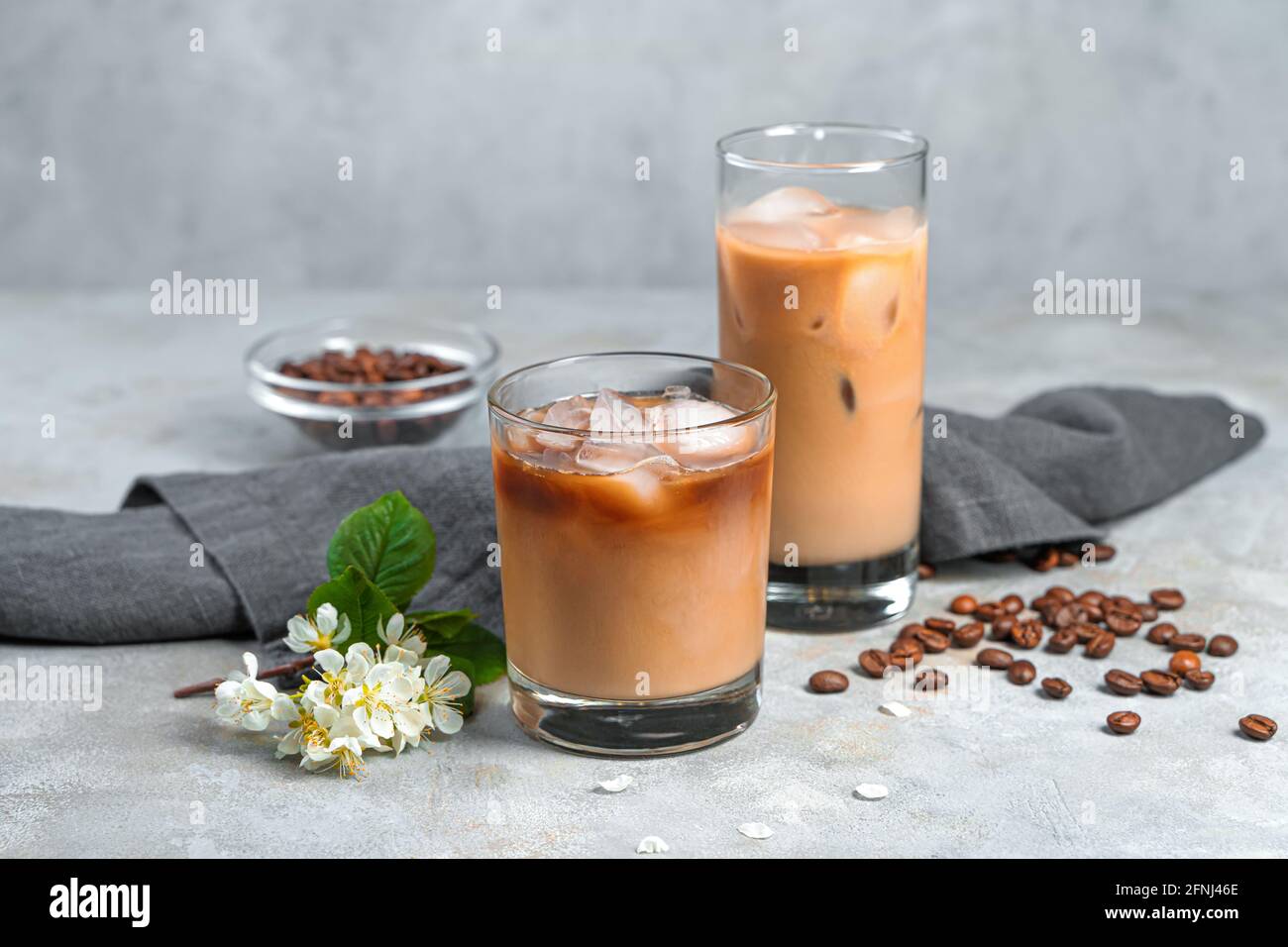 Cooling iced coffee in two glasses on a gray background. The side view ...