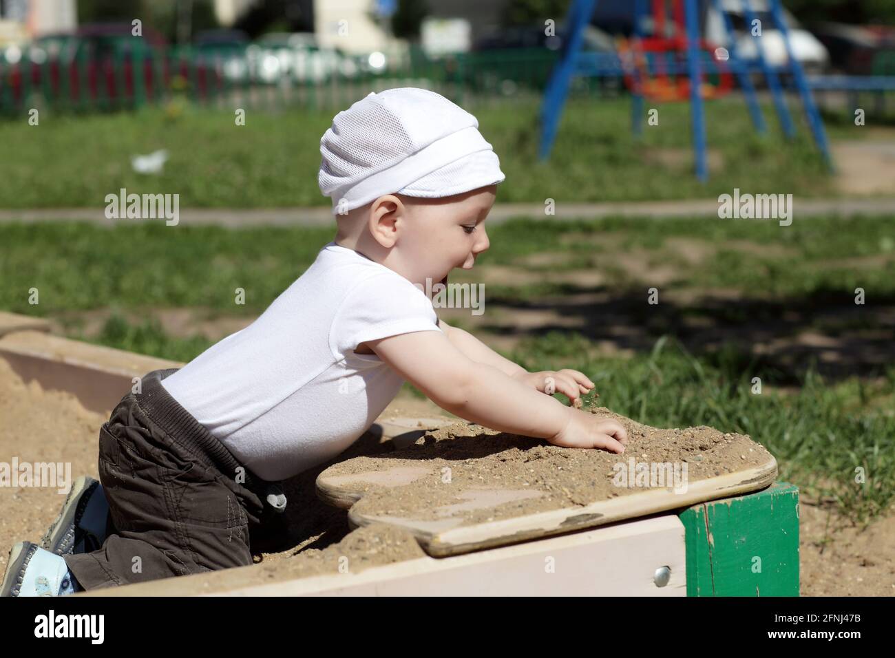 Happy boy playing in sandbox on a playground Stock Photo - Alamy