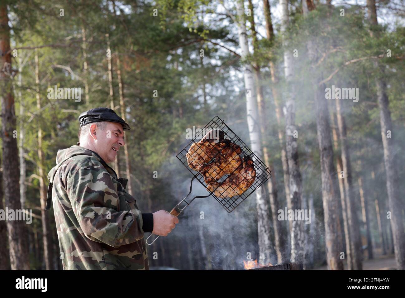 Portrait of man with meat grill in a forest Stock Photo - Alamy