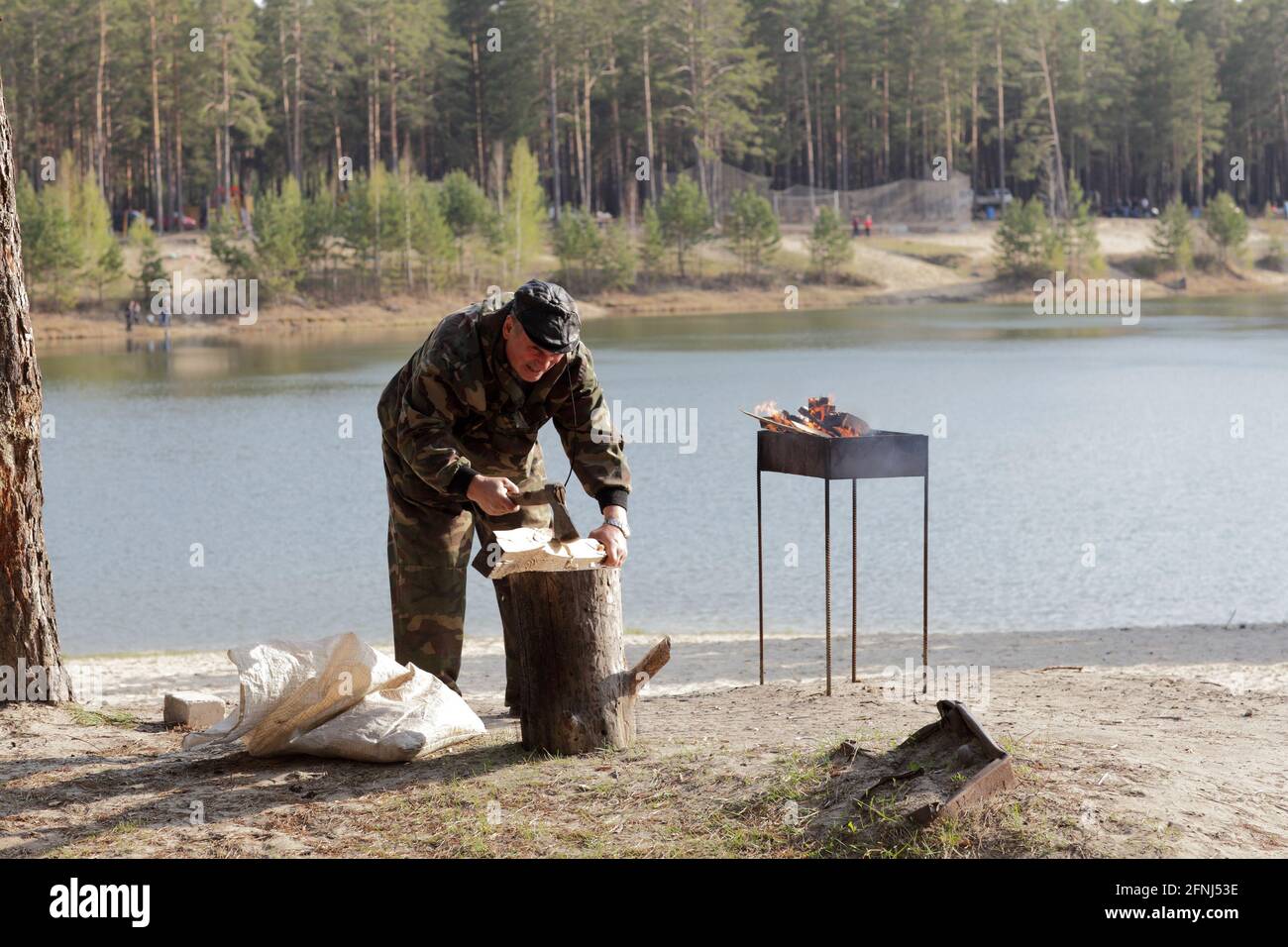 Man splitting firewood for preparation of barbecue in forest Stock ...