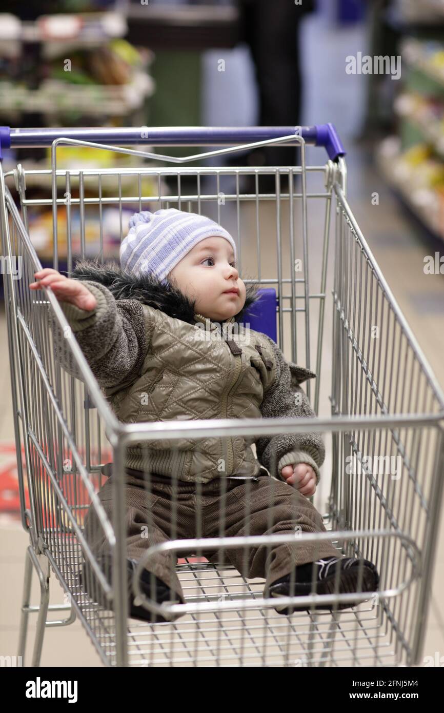The child in a shopping cart at market Stock Photo - Alamy
