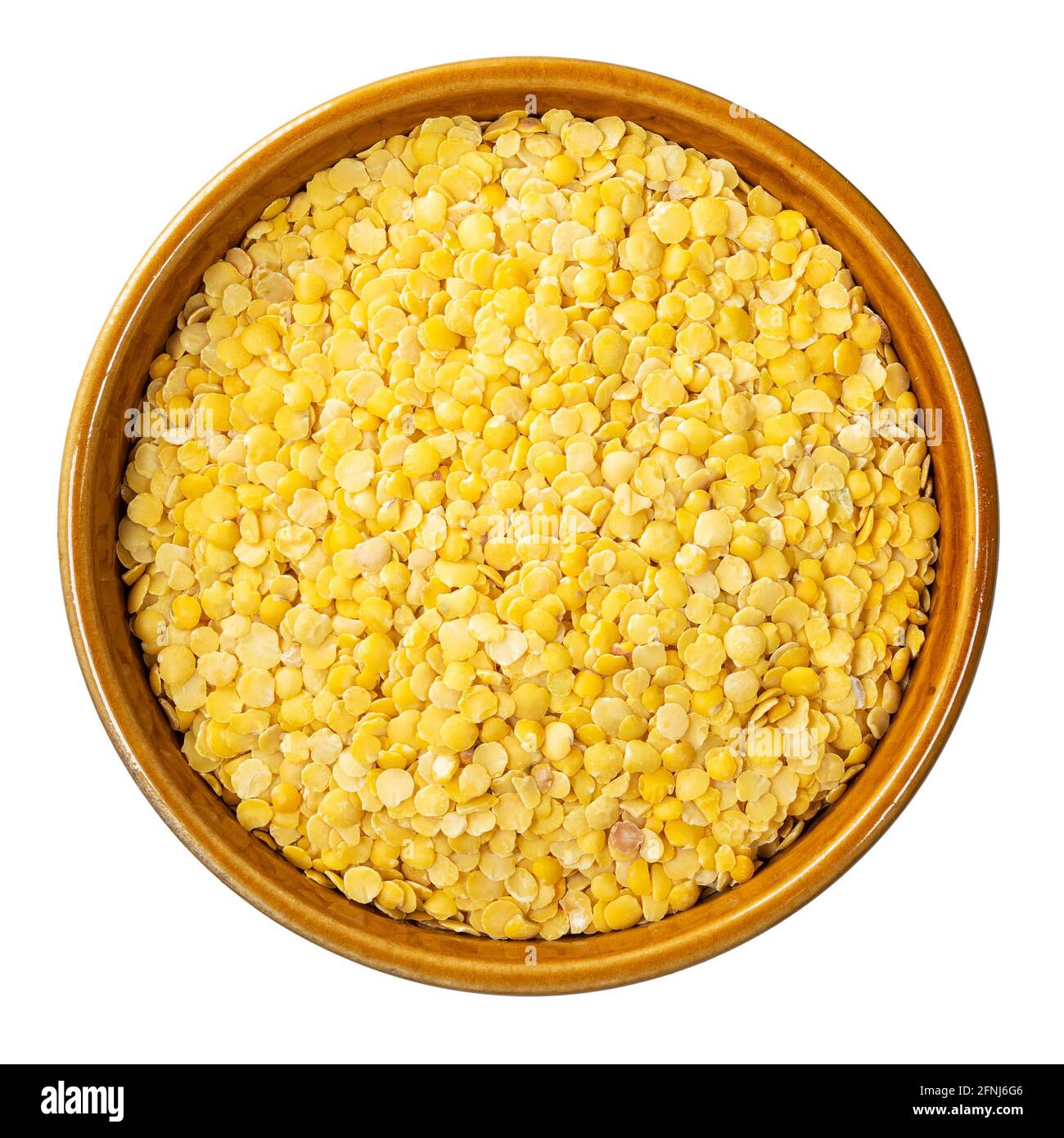 top view of split yellow lentils in measuring cup cutout in round bowl ...