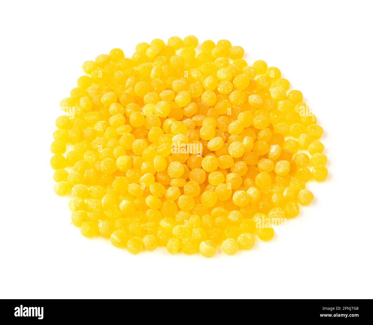 handful of uncooked ptitim (Israeli couscous) closeup on white ...