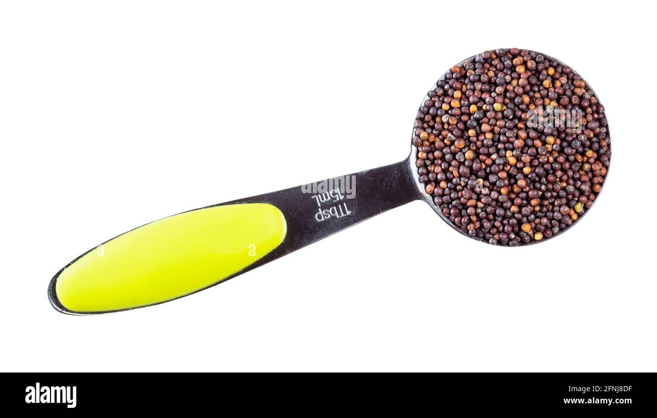 top view of rapeseeds in measuring tablespoon cutout on white ...